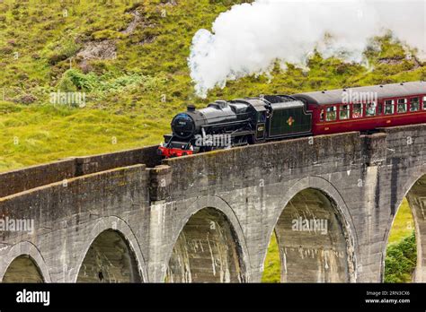 Famous Steam Training Passing Over A Curved Viaduct At Glenfinnan In