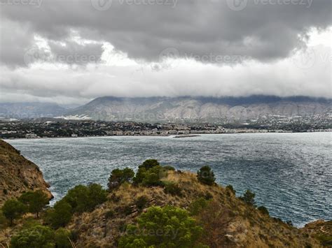 Windswept Shrubs Over Rugged Cliffside Bay Dramatic Scene Of Stormy