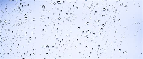 흰색 유리에 빗방울이 있는 최소한의 조명 배경 비오는 물방울이 있는 가벼운 젖은 창문이 푸른 빛으로 근접 촬영됩니다 빗방울이 있는 창 유리의 흐릿한 미니멀리스트 흑백 배경이