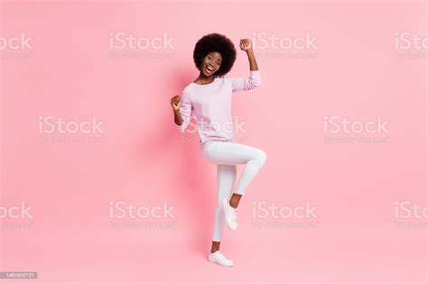 쾌활한 물결 모양의 머리카락을 가진 소녀의 전체 길이 몸 크기 전망은 분홍색 배경에 고립 된 재미를 가지고 춤을 추는 편안한