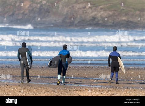 Polzeath Surfing Three Surfers Carrying Their Surfboards And Walking
