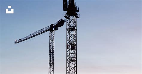 타워 크레인이 푸른 하늘을 배경으로 실루엣으로 그려져 있습니다 사진 Unsplash의 무료 건설 현장 이미지