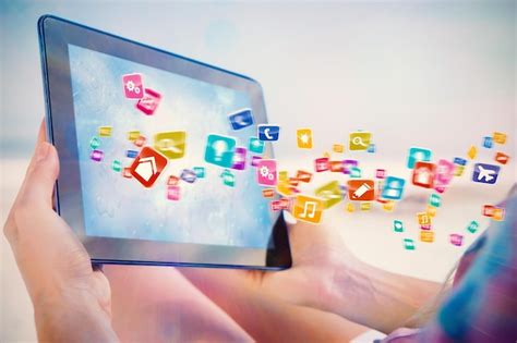 다채로운 컴퓨터 응용 프로그램을 보여주는 태블릿 Pc를 사용하여 야외용 데크 의자에 앉아 해변에 앉아 있는 여성 프리미엄 사진