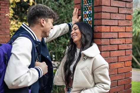 Premium Photo College Babe With Backpack Seducing Latina Girl Leaning On Wall