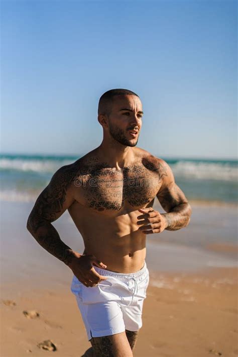 Atrakcyjny Topless Man Z Tatuażami Biegnącymi Na Plaży Obok Morza Obraz