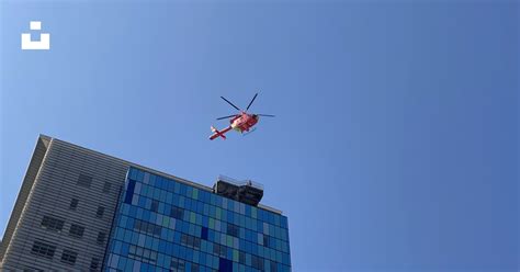 낮 동안 건물 위를 비행하는 빨간색과 흰색 헬리콥터 사진 Unsplash의 무료 스테프니 웨이 이미지