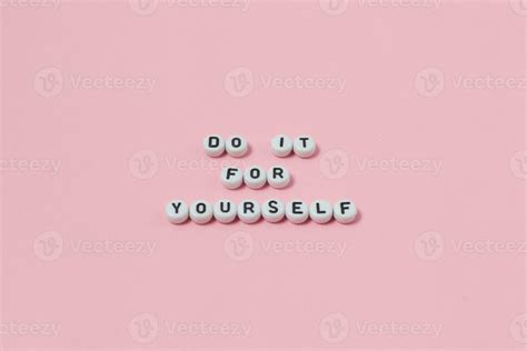 Top View Of Do It For Yourself Quotes Made Out Of Beads On Pink