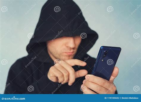 Faceless Unrecognizable Hooded Person Using Mobile Phone Identity