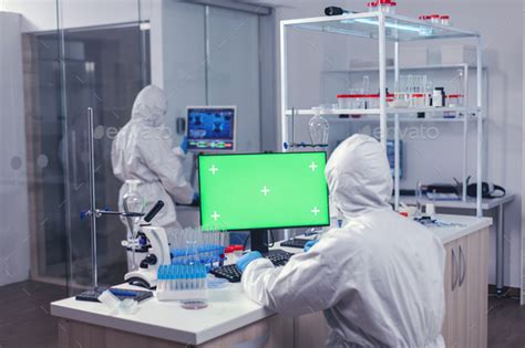 Scientist Conducting Experiment Using Computer With Green Screen Stock