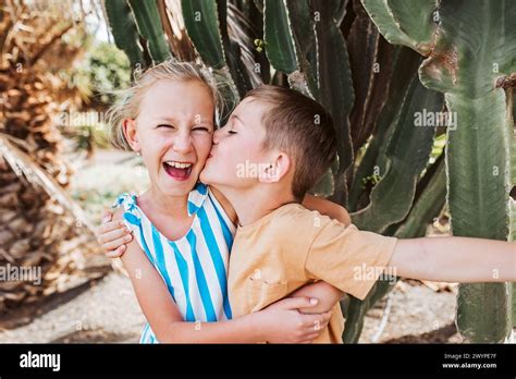 Portrait Of Siblings On Summer Vacation In Holiday Destination Happy Brother Kissing Babe On