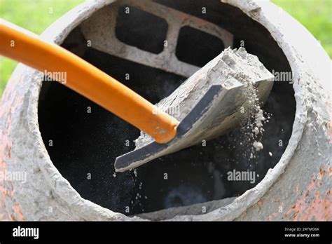 Construction Site Adding Lime Sand And Stones To Rotating Cement