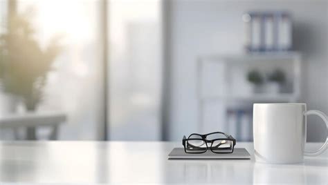 A White Cup And A Pair Of Reading Glasses On A Table Premium Ai
