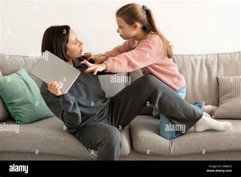 Strict Caucasian Middle Aged Mother Takes Tablet From Dissatisfied Sad