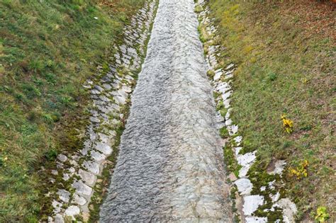 Narrow Stone Lined Stream Flowing Through Lush Green Landscape Spring