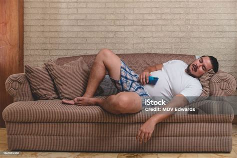 과체중이고 면도되지 않고 게으른 혼혈 인종의 남자가 소파에서 잠을 자고 여전히 핸드폰을 들고 있다 35 39세에 대한 스톡 사진 및 기타 이미지 Istock