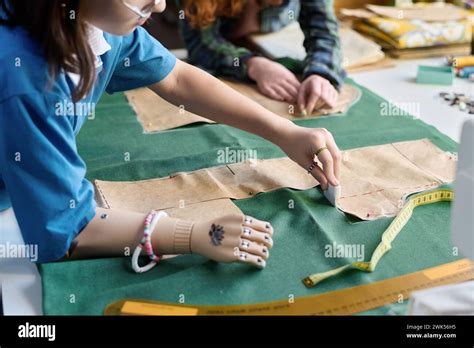 Cropped Shot Of Girl With Prosthetic Arm Making Clothing And Tracing