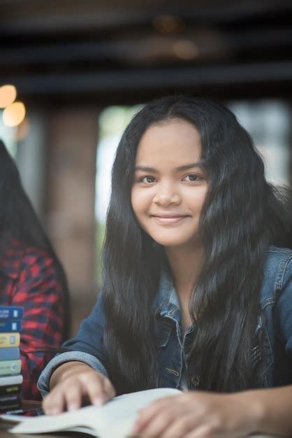 Premium Photo Portrait Of Smiling Girl Sitting At Table