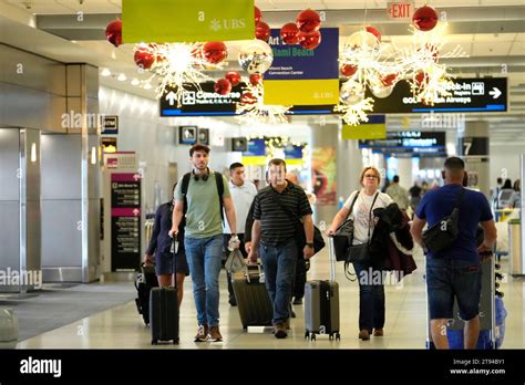 Travelers Walk Along The Concourse At Miami International Airport Ahead