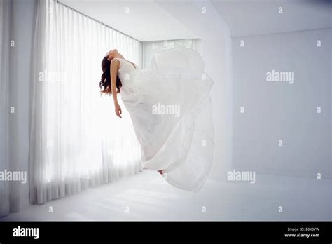 A Woman Floating In A Room Next To The Window Stock Photo Alamy