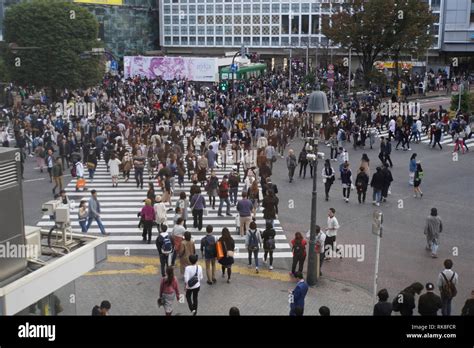 Elevated View Of A Crowed Of Pedestrians Crossing A Four Way Zebra