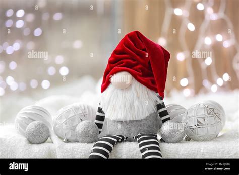 Christmas Gnome And Balls On Light Fabric Against Glowing Lights Stock