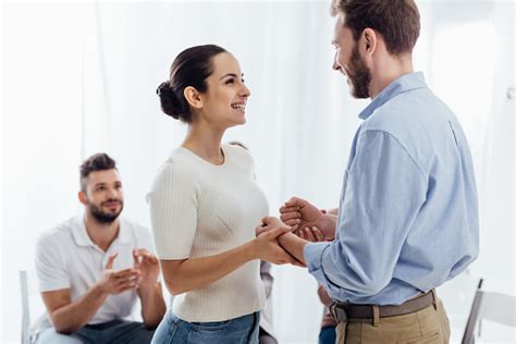 그룹 치료 세션 동안 남자와 손을 잡고 아름다운 웃는 여자 3 명에 대한 스톡 사진 및 기타 이미지 3 명 그룹 치료