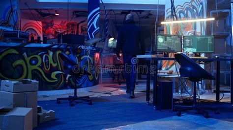 Hooded Hacker Arriving In Hidden Neon Lit Underground Shelter With