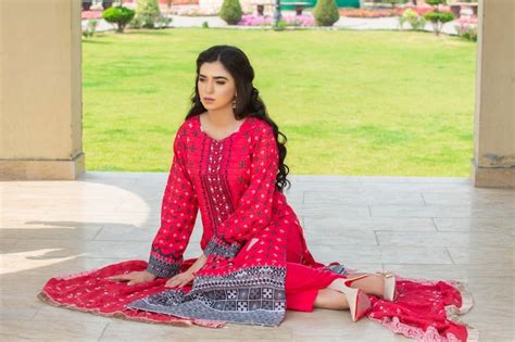 Premium Photo Pretty Girl Sitting On Floor In A Garden Wearing Red