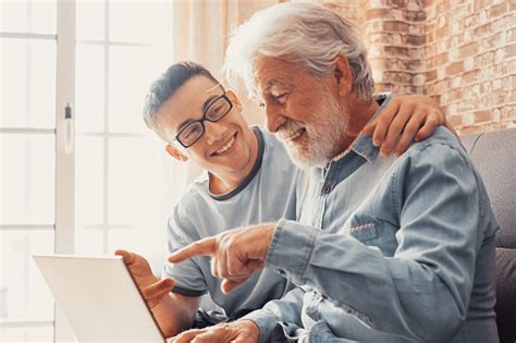 Photo Libre De Droit De Jeune Garçon Souriant Aidant Grandpère Âgé Avec