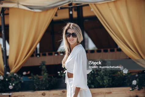 하얀 양복을 입고 패셔너블한 아름다운 금발 모델 여자가 여름 카페에서 포즈를 취하고 있다 35 39세에 대한 스톡 사진 및 기타 이미지 35 39세 개념 거리