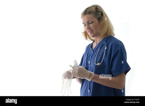 Photo Of Nurse With Stethoscope Putting On Gloves And Holding A Syringe