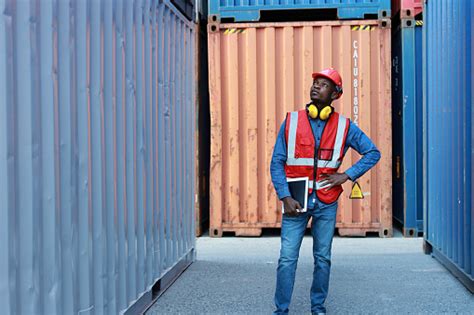 태블릿과 워키토키 무선 조종 적재 컨테이너 상자를 사용하는 감독 안전모를 쓴 엔지니어 또는 작업자는 컨테이너 화물 현장에서 작업하고 산업용 컨테이너 화물 화물선을 점검합니다