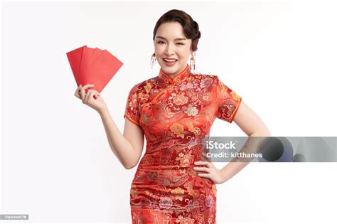흰색 배경에 격리된 앙파오 또는 빨간색 패킷 화폐 선물을 들고 있는 전통적인 치파오 치파오 드레스를 입은 아시아 여성 중국 설날