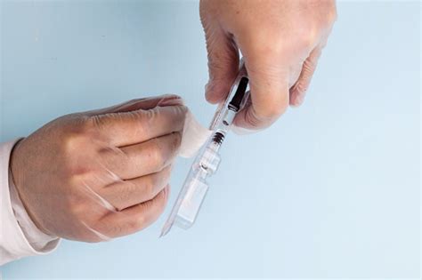 투명 의료 니트 릴 장갑의 수 컷 손은 피하 투여를 위한 얇은 바늘로 약을 가진 작은 주사기를 보유 하 고 있습니다 의학의 개념 혈전의 예방 두꺼운 혈액 Ivf 간호사에