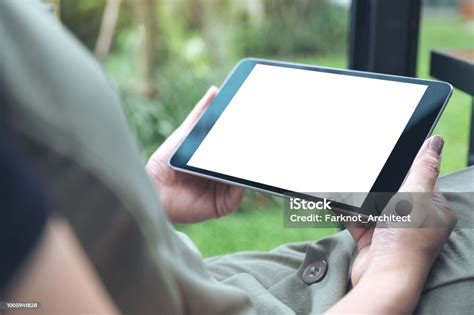 이랑 이미지의 여자의 손을 들고 검은 태블릿 Pc 흰색 빈 화면이 녹색 자연 배경으로 카페에 앉아있는 동안 공란에 대한 스톡