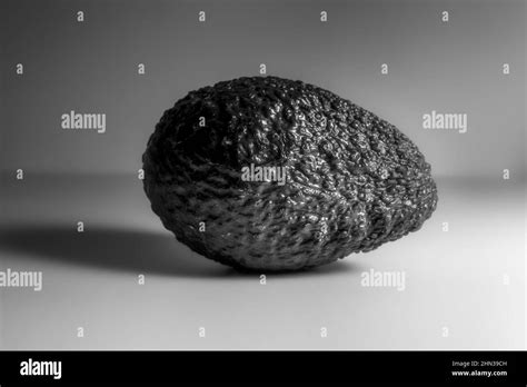 Grayscale Shot Of An Avocado On A Reflective Surface Against A White