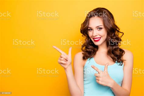 쾌활 한 긍정적인 요 염 한 몸짓 빈 복사본 공간을 보여주는 2 개의 Forefingers의 장소 카메라 노란색 배경 광고 개념에 고립 된 보고 가리키기에 대한 스톡 사진