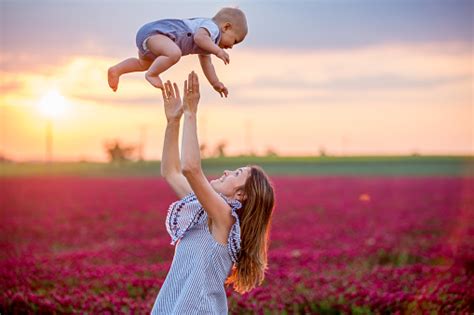 젊은 어머니 부드러움으로 포용 하 고 신경 그녀의 유아 아기 크림슨 클로버 필드에서 행복 하 게 웃 고 꽃 식물에 대한 스톡 사진 및 기타 이미지 Istock