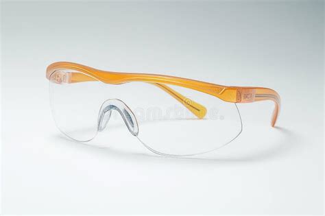 Pair Of Orange Safety Glasses Laying On A White Surface Stock Image