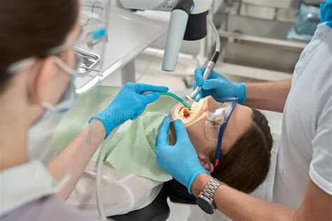 Experienced Doctor Conducting Dental Calculus Removal Under Microscope