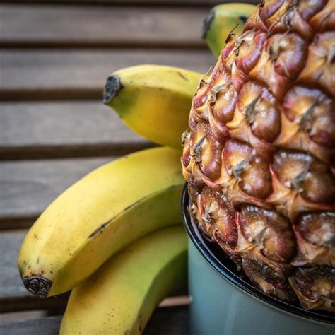 Premium Photo Close Up Of Bananas With Pineapple On Table