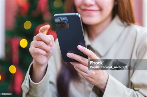 크리스마스 파티에서 휴대 전화를 들고 사용하는 여성의 근접 촬영 이미지 35 39세에 대한 스톡 사진 및 기타 이미지 35 39세 Brand Name Online