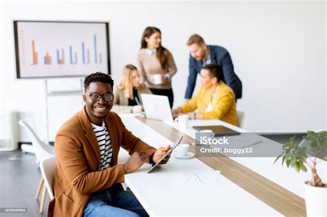 회의실에서 동료 앞에서 디지털 태블릿으로 일하는 젊은 아프리카 계 미국인 사업가 20 24세에 대한 스톡 사진 및 기타 이미지