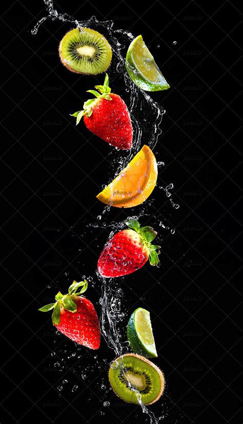 عکس برش های میوه در آب در پس زمینه مشکی عکس با کیفیت و تصاویر استوک
