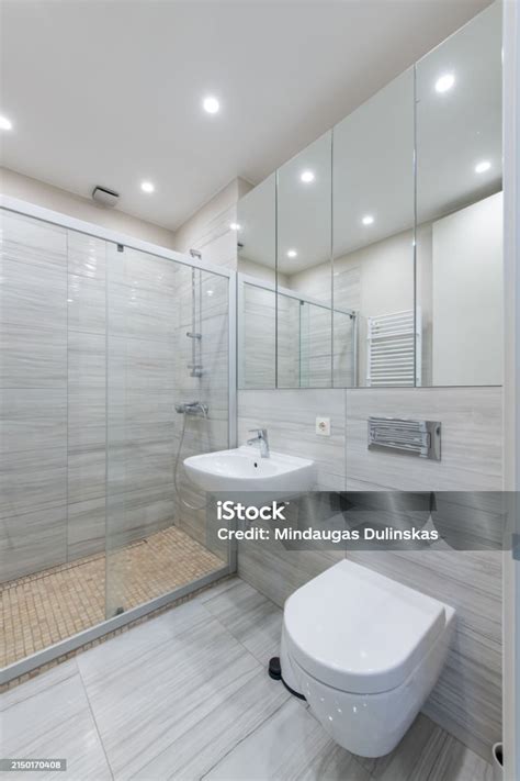 흰색 세면대가 있는 샤워실의 밝고 우아한 현대적인 미니멀리스트 욕실 인테리어 디자인 욕실 액세서리 회색 벽 콘크리트 바닥 거울 0명에 대한 스톡 사진 및 기타 이미지