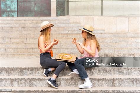 휴일을 즐기고 피자와 계단에 앉아 패스트 푸드를 즐기는 도시에서 피자를 먹는 여성 친구 2명에 대한 스톡 사진 및 기타 이미지