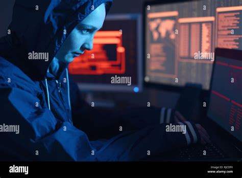 Girl Hacker In A Hood Typing Program Code While Committing A Cybercrime