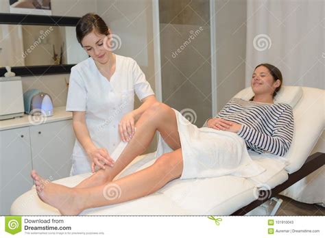 Beautiful Lady Cosmetician Providing Procedure Leg Hair Removal Stock