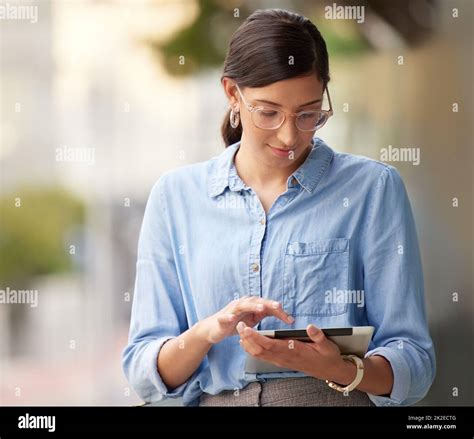 Doing Some Work On The Go Shot Of A Young Businesswoman Using Her