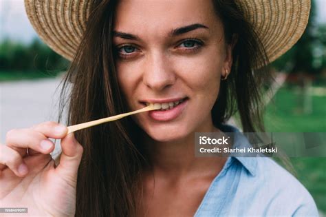 모자를 쓴 젊은 여자는 입에서 노란 껌을 뻗고 도시 공원에서 하얀 이빨을 보여준다 긍정 개념 20 24세에 대한 스톡 사진 및 기타 이미지 Istock